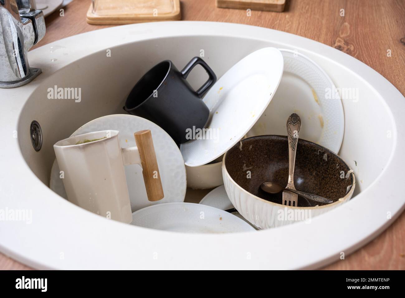 Dirty dishes in the sink in the kitchen, mess after lunch, too lazy to ...
