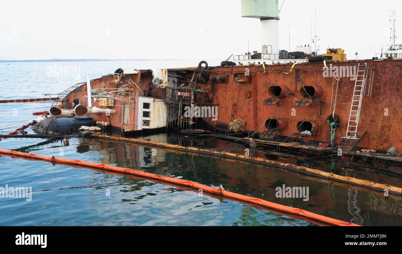 Close up of overturned oil tanker lying on its edge on the shallow ...