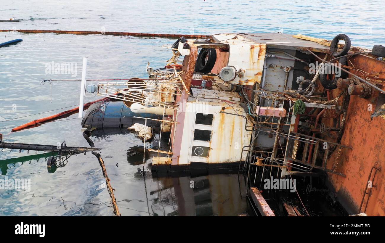 Overturned oil tanker ship in the shallow water. Close up sunken ...