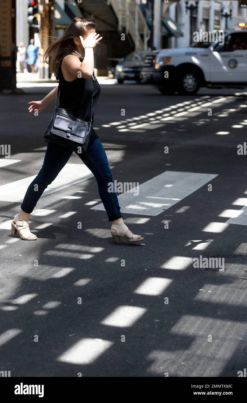 A woman crosses over State Street in Chicago's famed Loop, Thursday ...