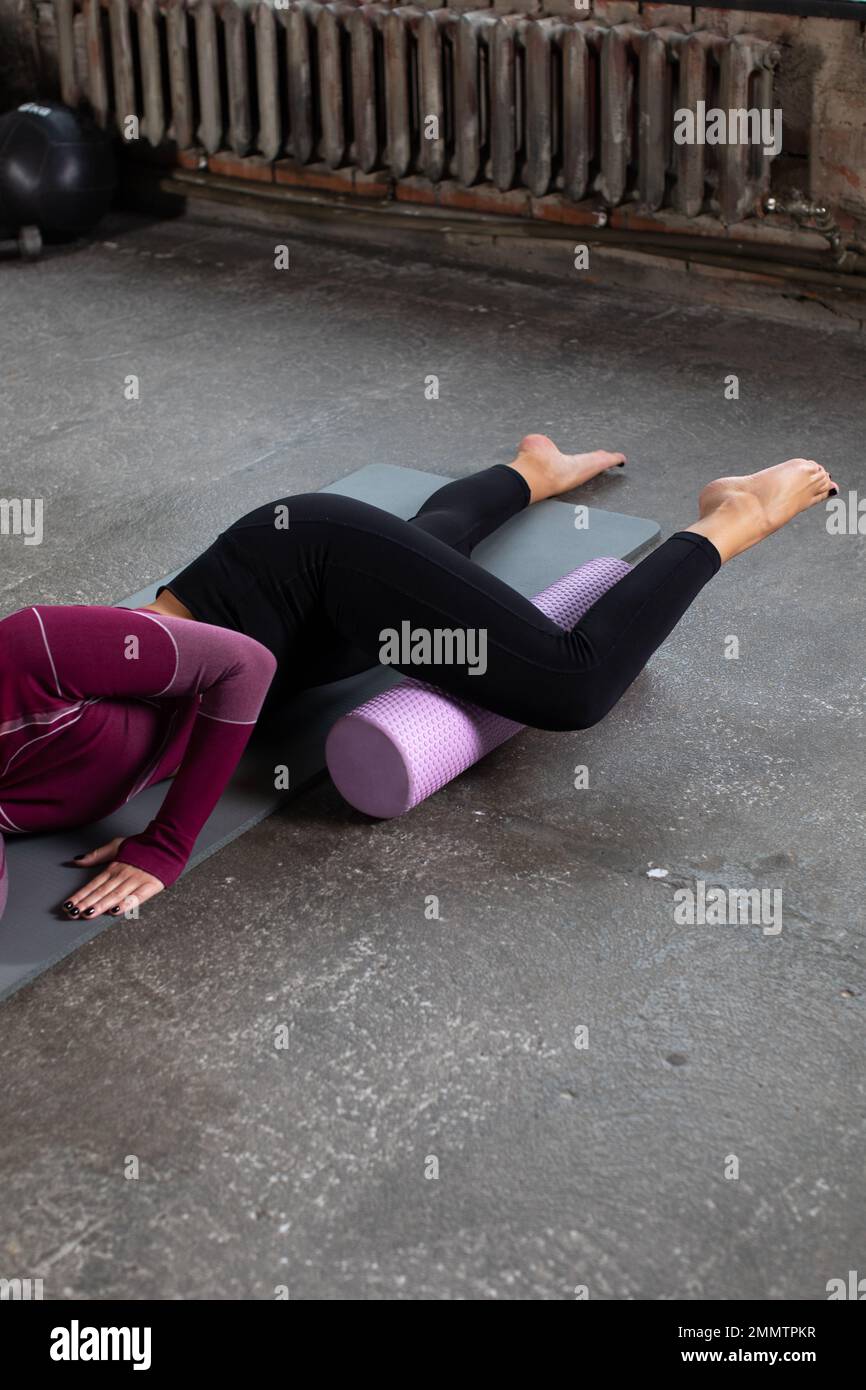 A Young Woman In Sportswear Performs A Myofascial Hip Massage With A Roller Muscle Recovery