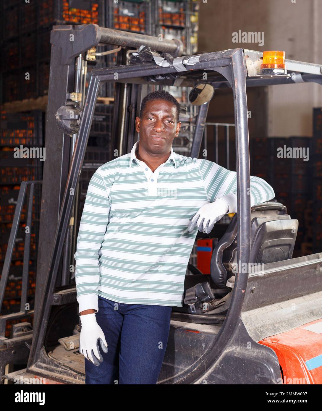 African American man standing near forklift at fruit warehouse Stock ...
