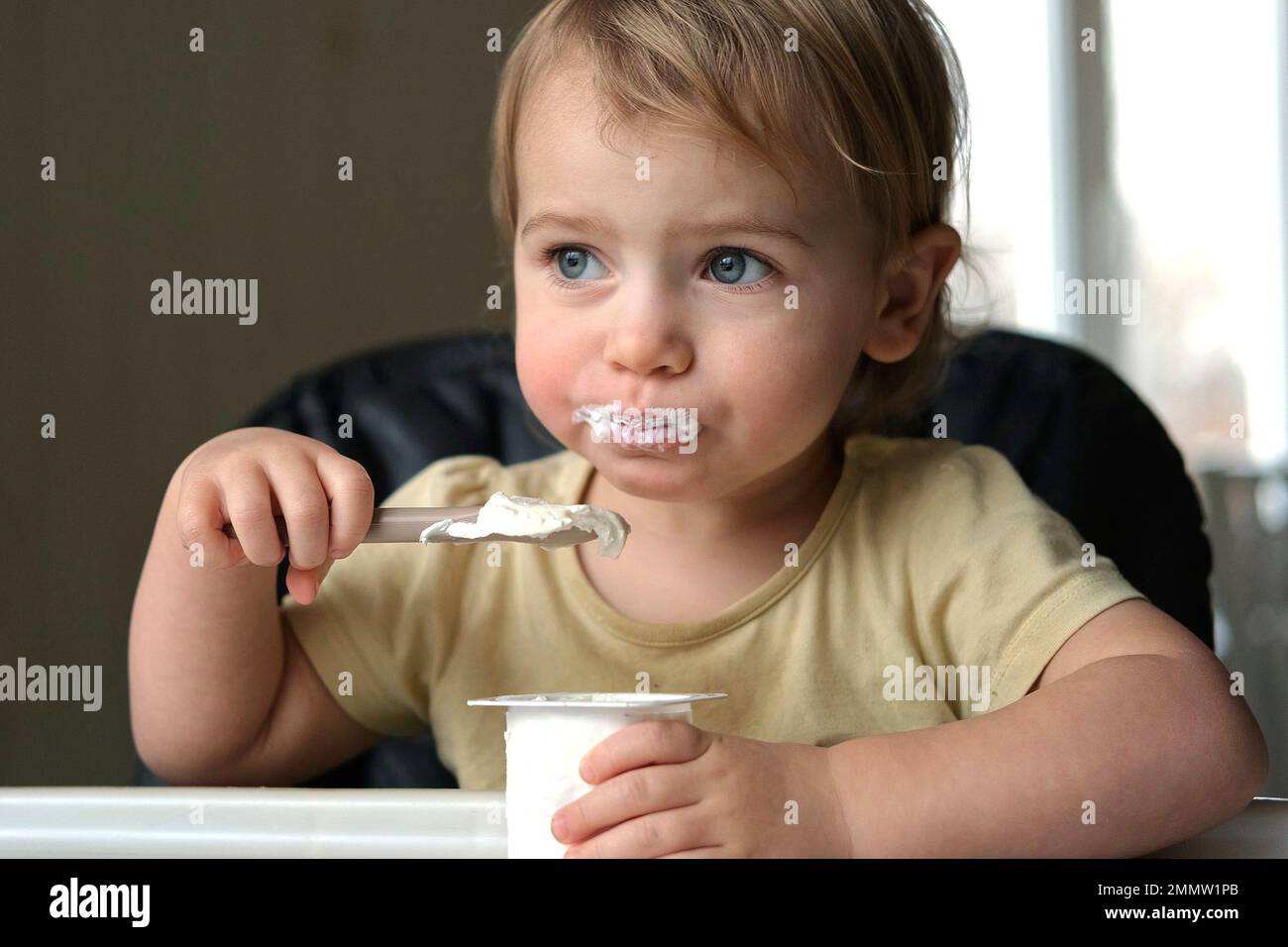 Young Kid Eating Blend Mashed Feed Sitting in High Chair. Baby Weaning ...