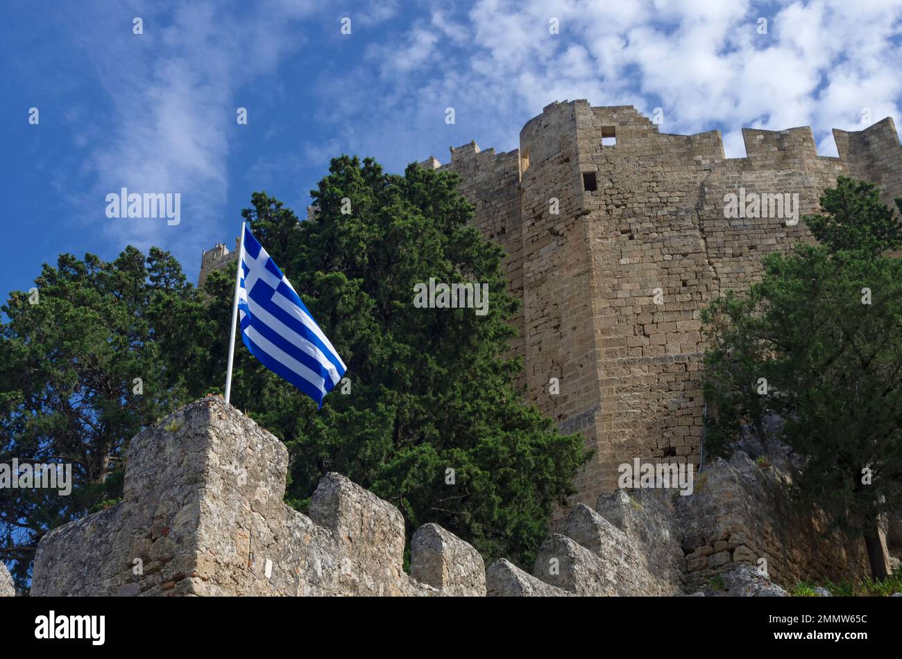 Medieval fortress of Lindos with the flag of Greece on the background ...