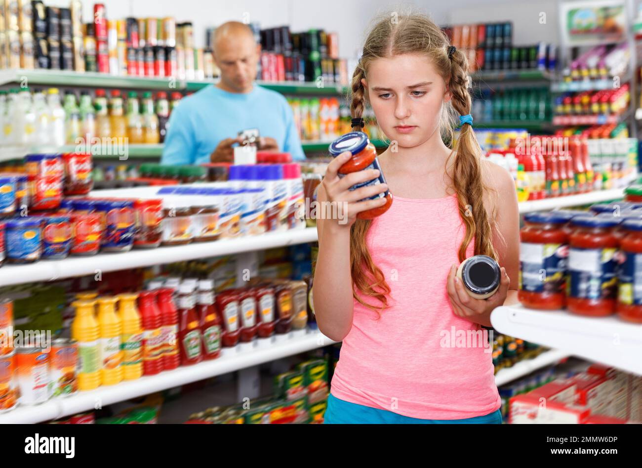 Tween girl choosing and buying food products at grocery shop Stock ...