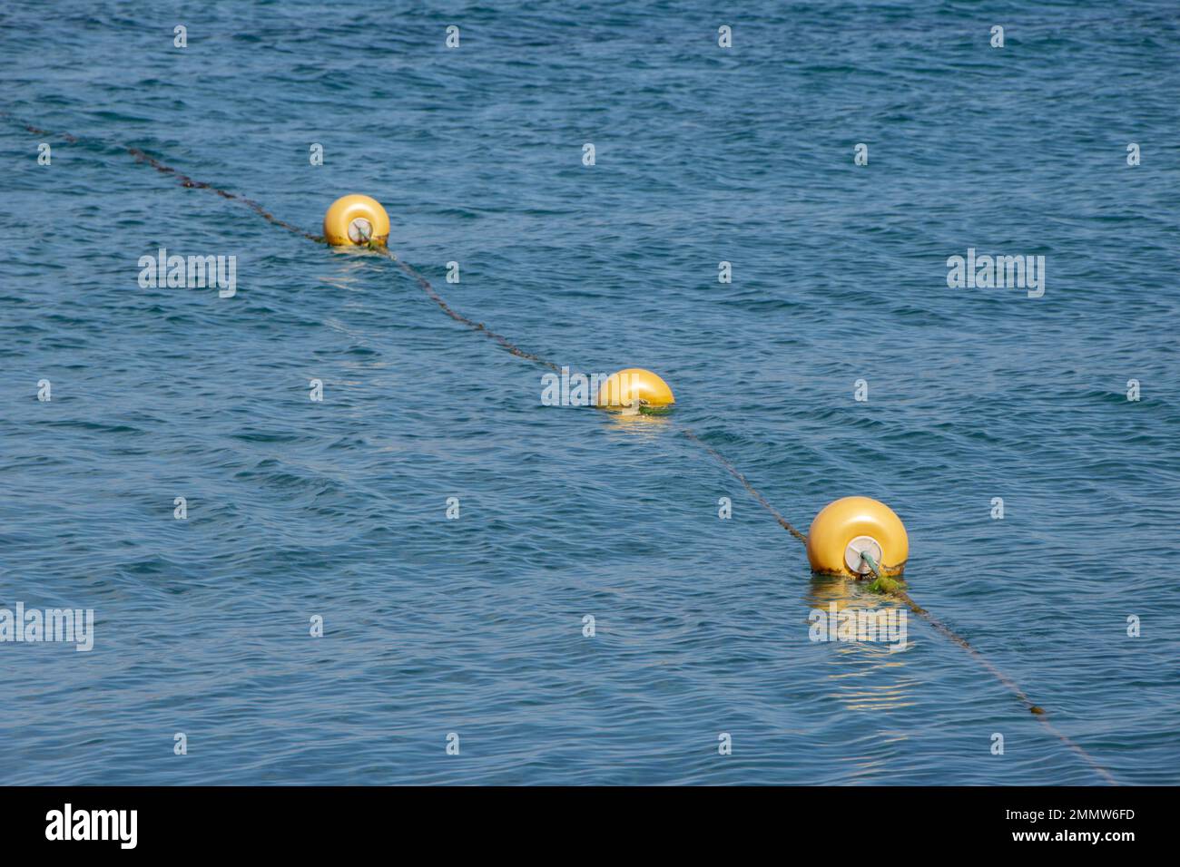 Three yellow buoys floating in the sea Stock Photo - Alamy