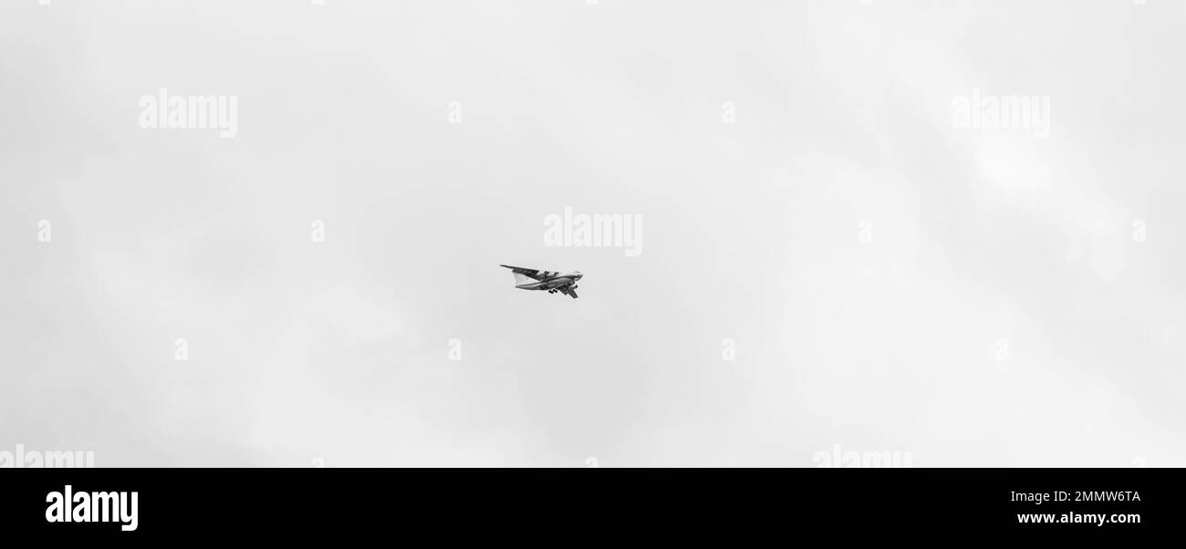 The fly of white aircraft in gray sky. flight Stock Photo - Alamy