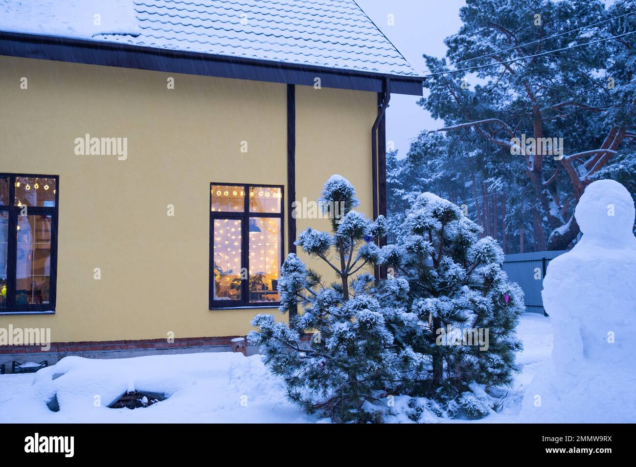 Cozy festive window of the house outside with the warm light of fairy ...