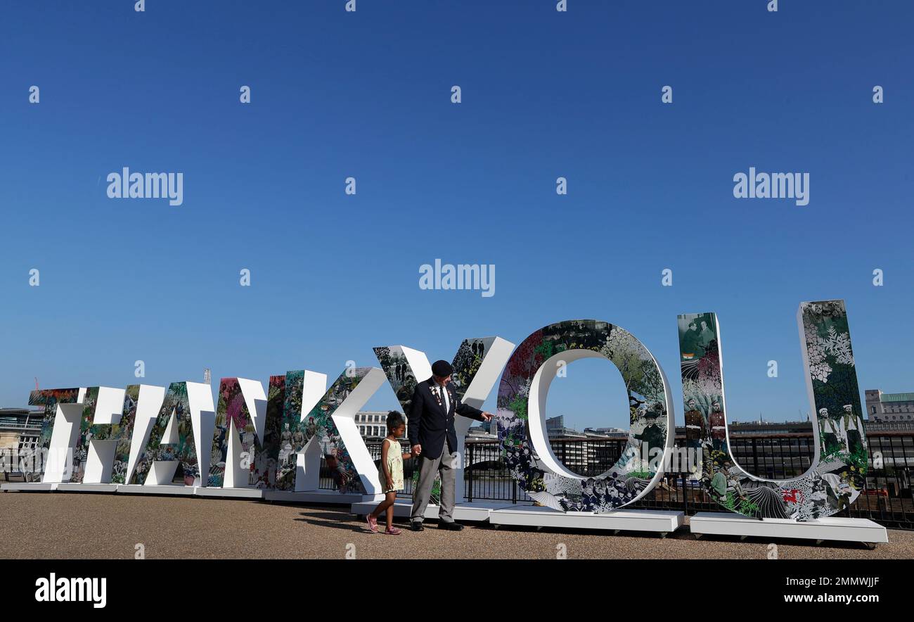 RAF veteran Tom Weatherall, 84, walks with Maraki Tewdros, 5, as he ...