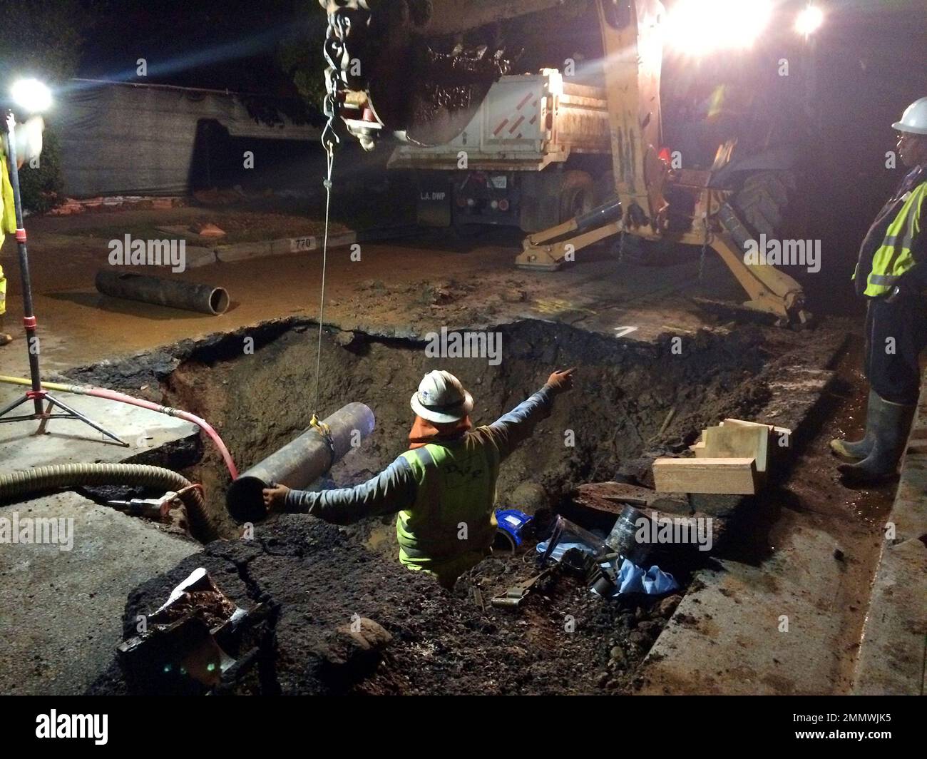 Los Angeles Department of Water and Power (DWP) workers lower a ...