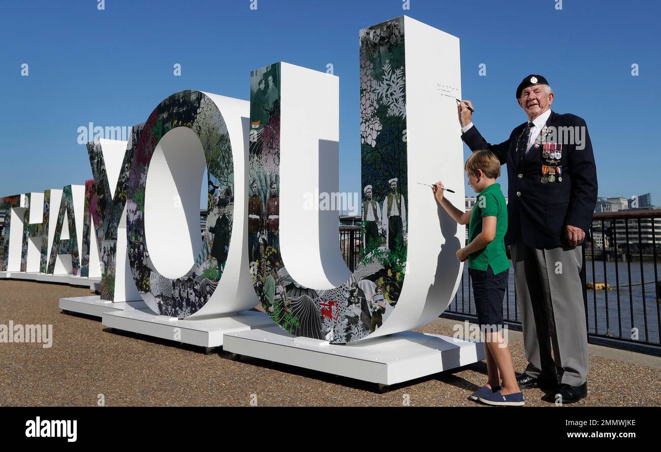 RAF veteran Tom Weatherall, 84, and Alex Axford, 8, write a message on ...