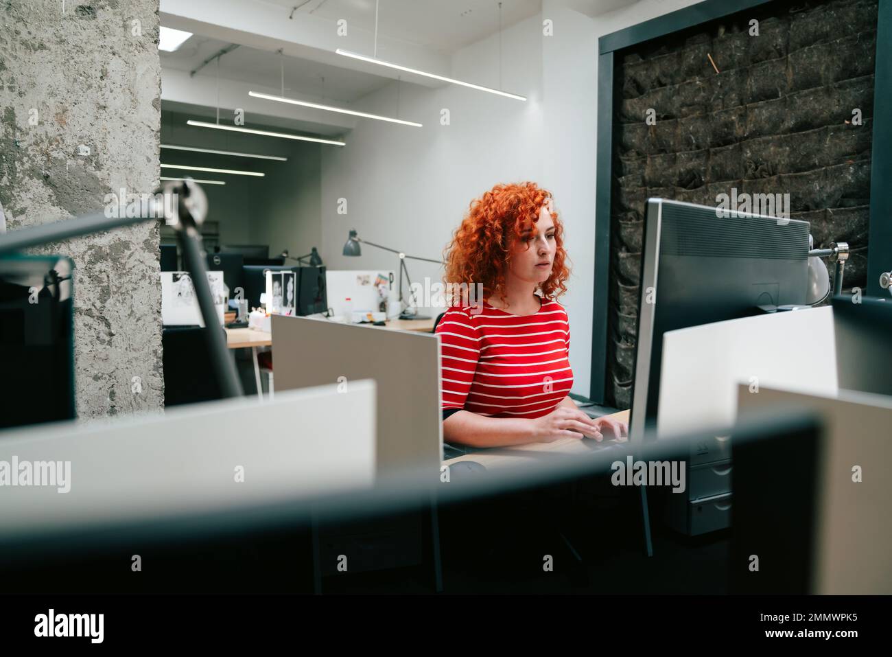 Young business woman working on desktop computer at modern startup ...