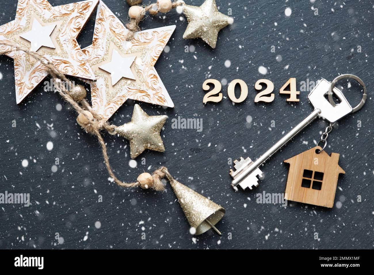 House key with keychain cottage on black background with stars ...