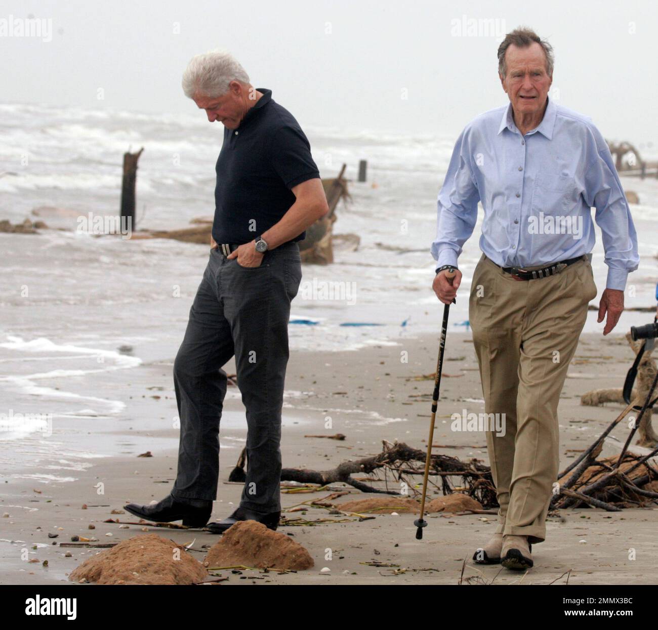 Former President Bill Clinton, left, kicks in the sand as former ...