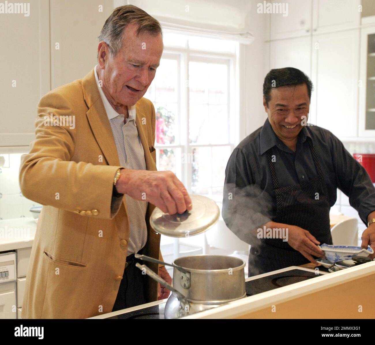 Former President George Bush, left, looks at the soup his personal chef ...