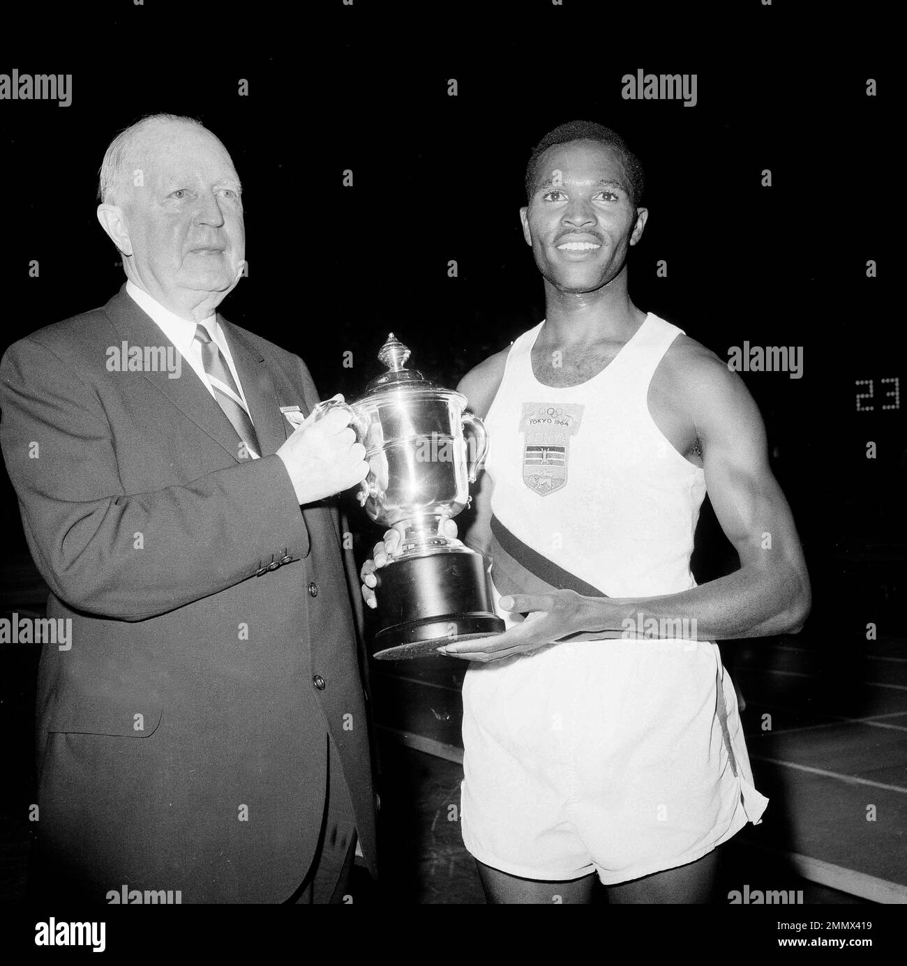 Kipchoge Keino, a Kenyan policeman, holds the cup he received for ...