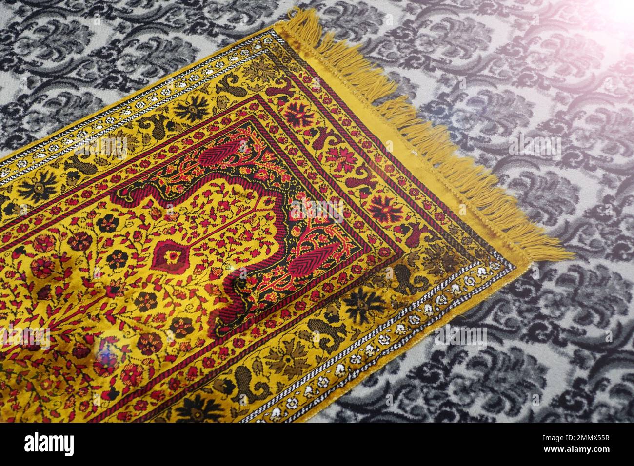Prayer is performed on the prayer rug laid in the masjid, yellow prayer ...