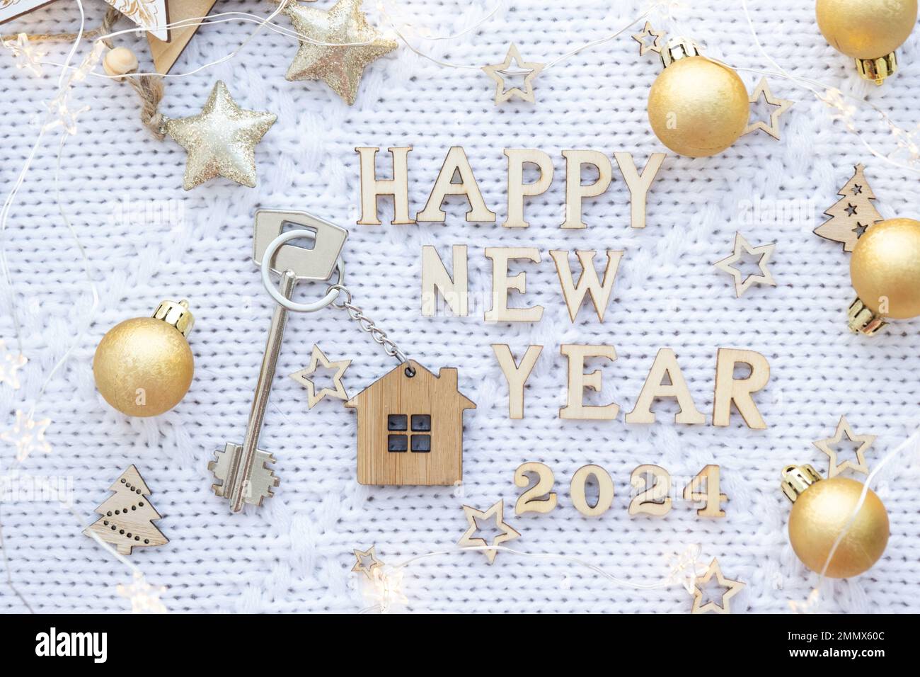 House key with keychain cottage on festive knitted background with ...