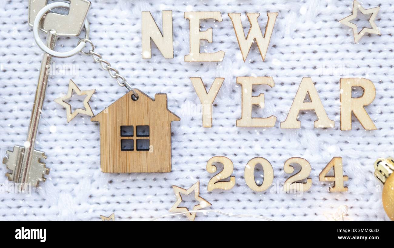 House key with keychain cottage on festive knitted background with ...