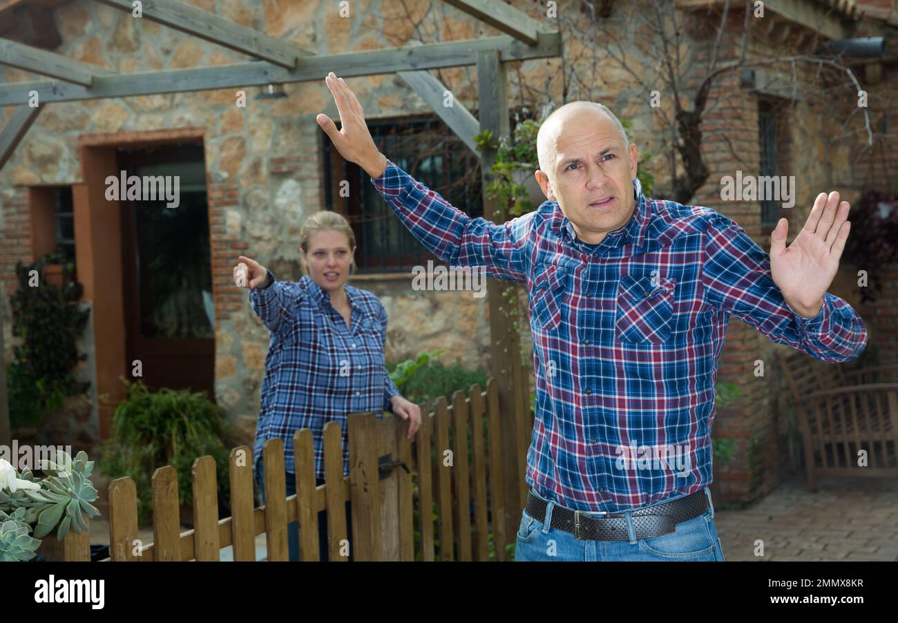 Irritated farmer with wife berating him Stock Photo - Alamy
