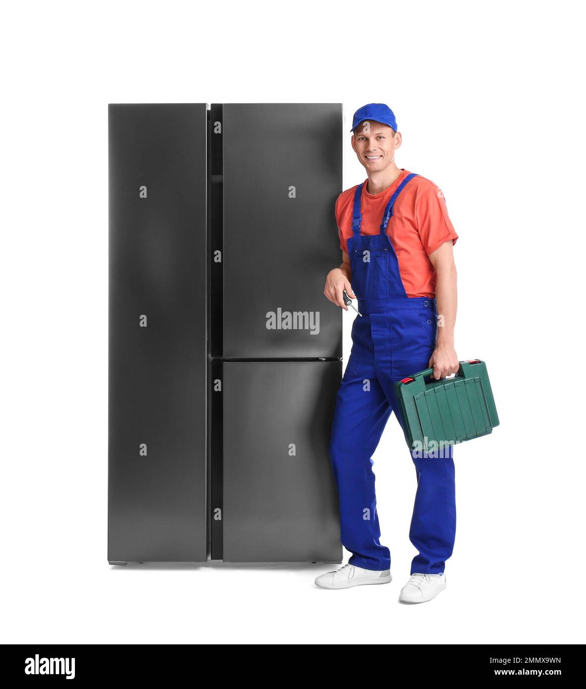 Male technician with tool box near refrigerator on white background ...