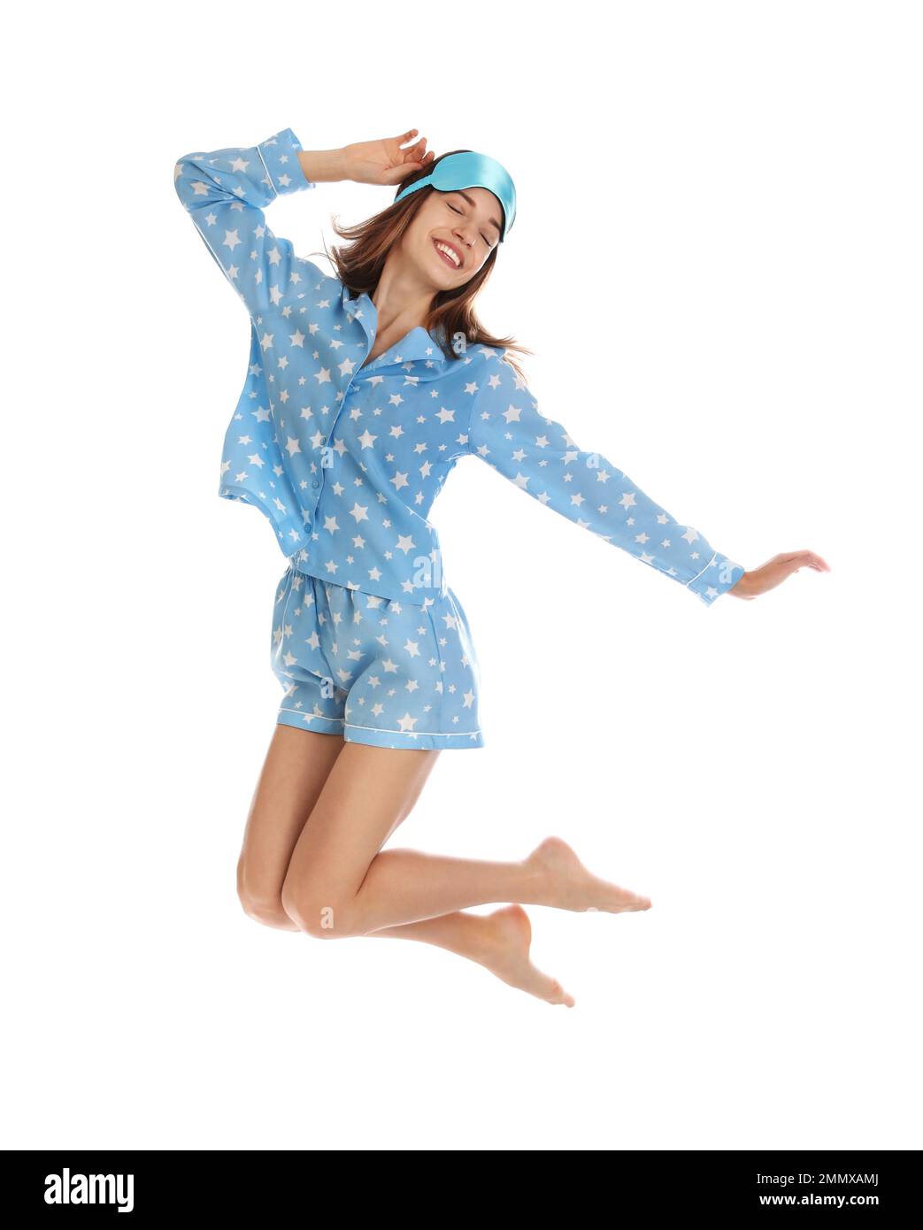 Beautiful woman with sleep mask jumping on white background. Bedtime ...