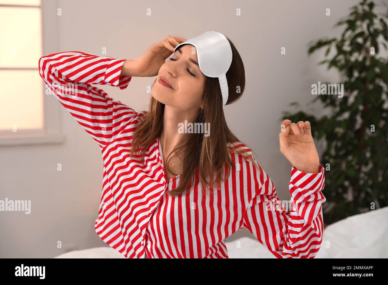 Beautiful woman wearing pajamas and sleep mask indoors. Bedtime Stock ...