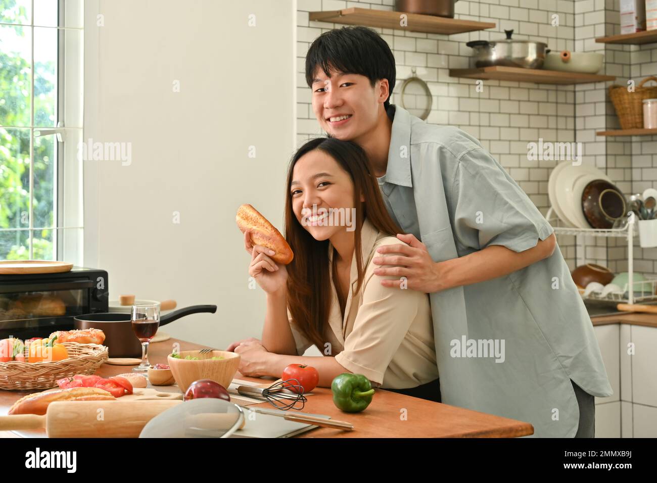 Romantic young couple is talking while cooking healthy food in kitchen ...