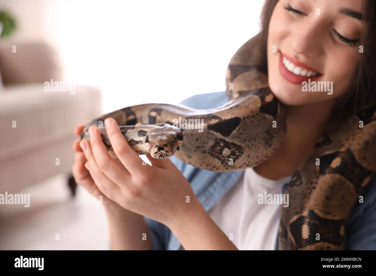 Young woman with her boa constrictor at home, focus on hand Stock Photo ...