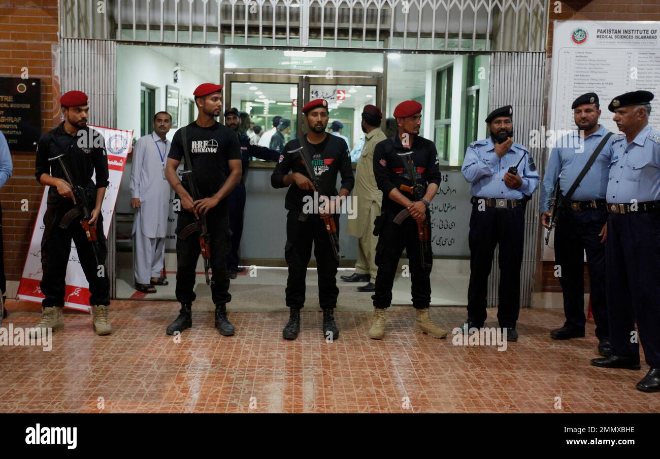 Pakistani police commandos stand guard outside the cardiac ward, where ...