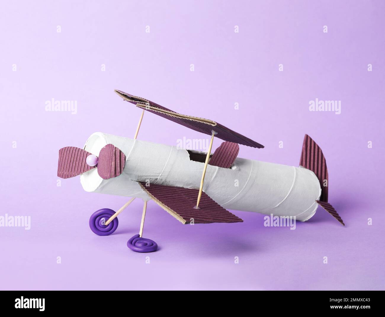 Toy plane made of toilet paper hub on lilac background Stock Photo - Alamy
