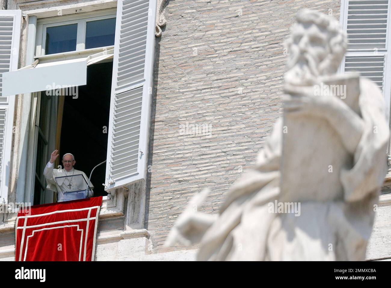 Pope Francis waves to faithful from his studio window overlooking St ...