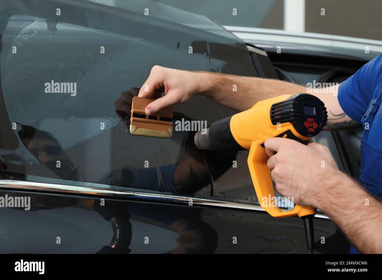 Worker tinting car window with heat gun in workshop, closeup Stock ...