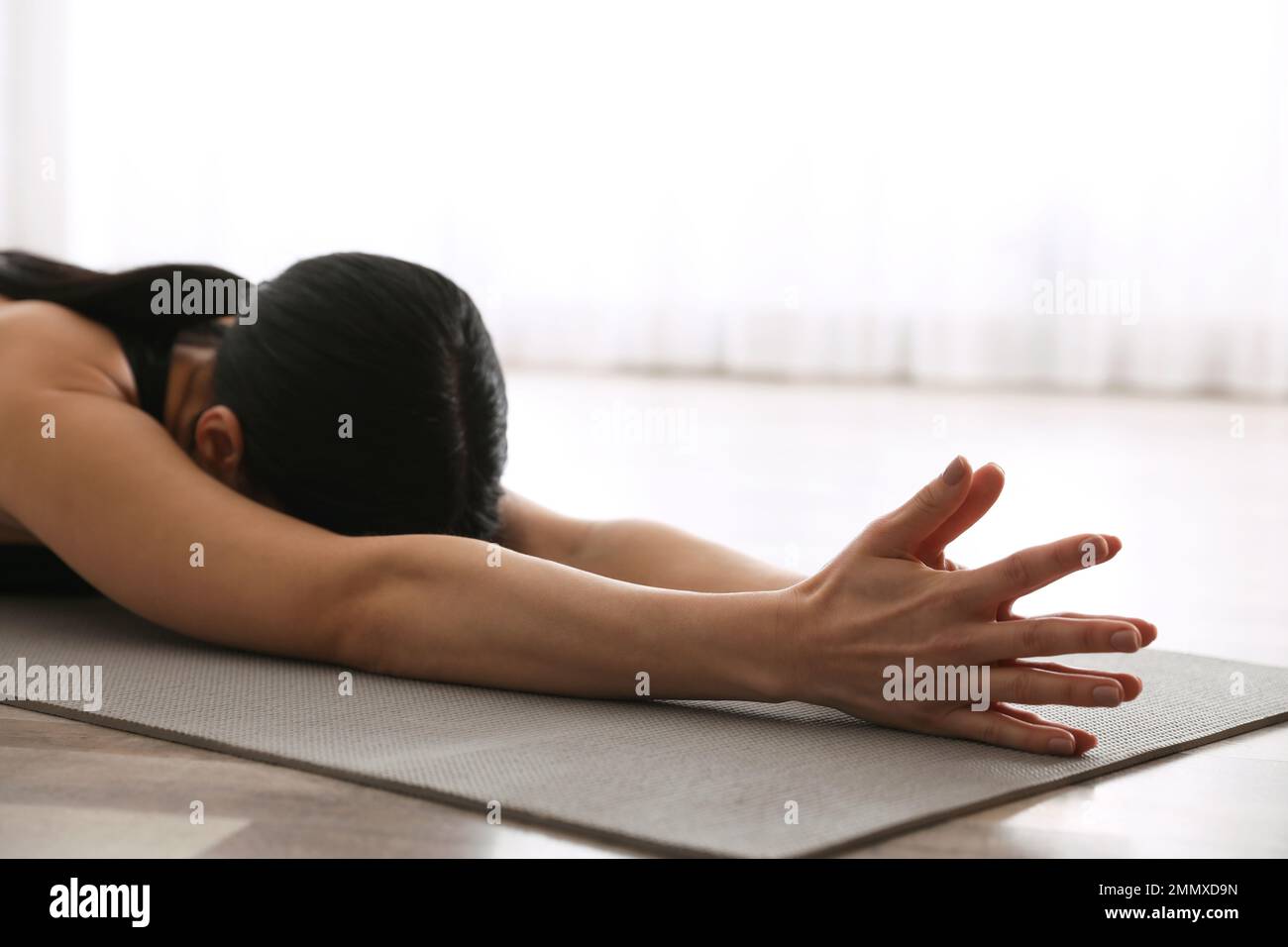 Young woman practicing extended child's asana in yoga studio, closeup ...