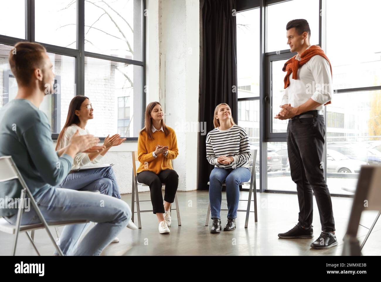 Psychotherapist working with patients in group therapy session indoors ...