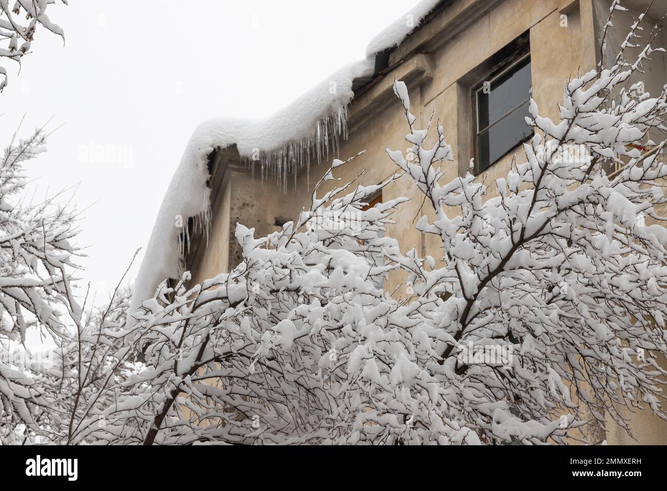 Facade of a residential building in the suburbs during a snowfall. The ...