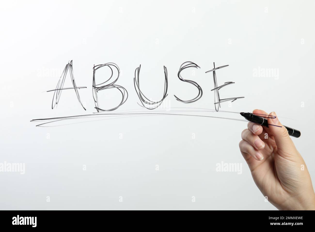 Woman writing word ABUSE on glass against white background, closeup ...