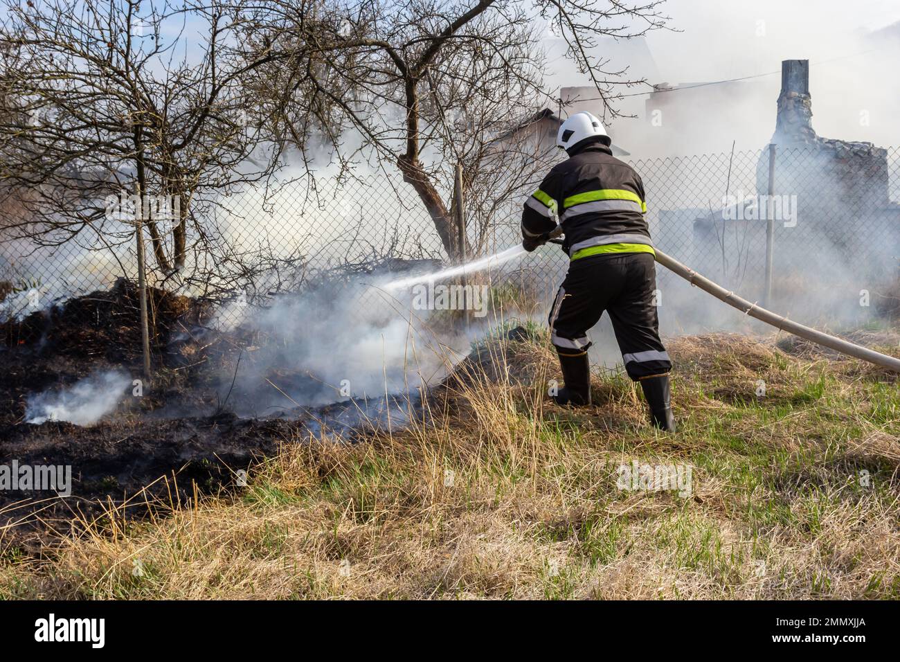 spring fire, burning dry grass near buildings in the countryside ...