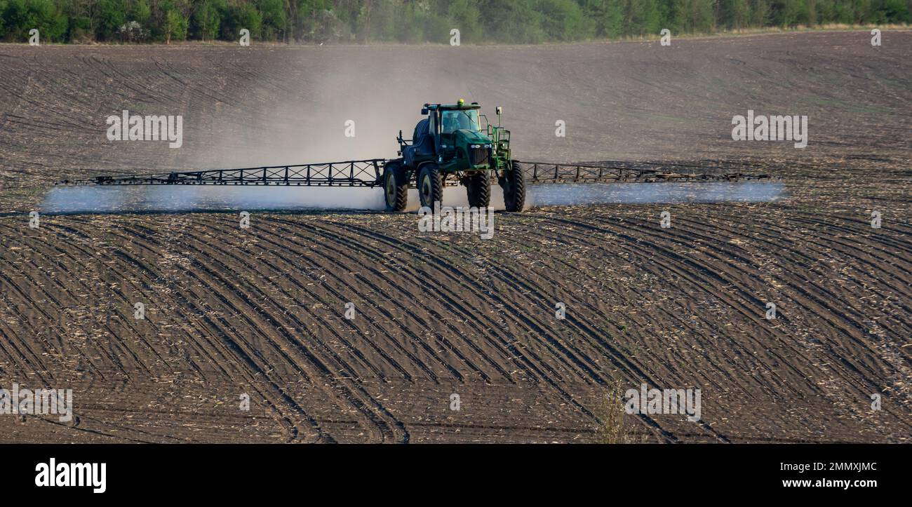 Tractor spray fertilizer spraying pesticides on green field ...