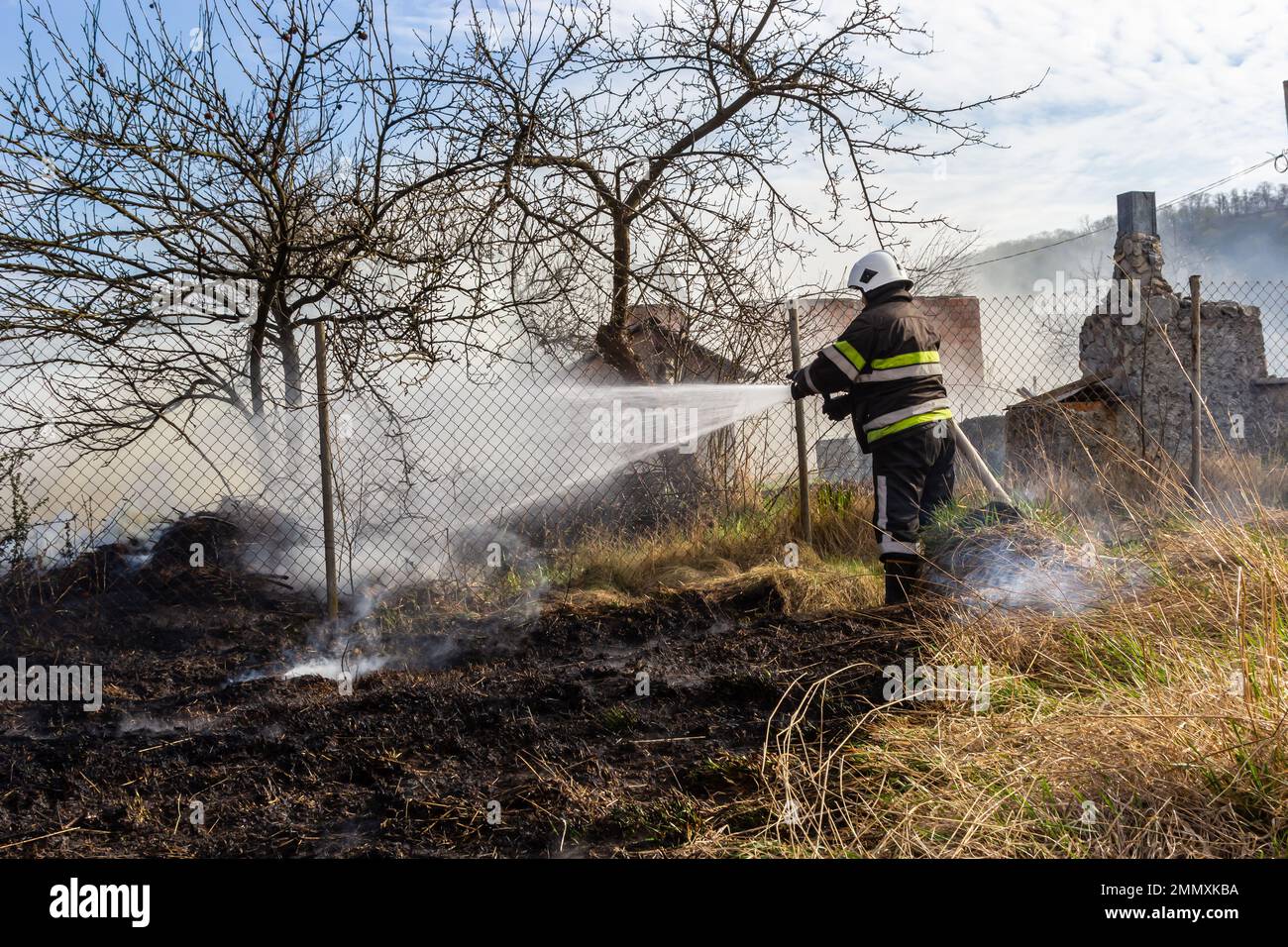 spring fire, burning dry grass near buildings in the countryside ...