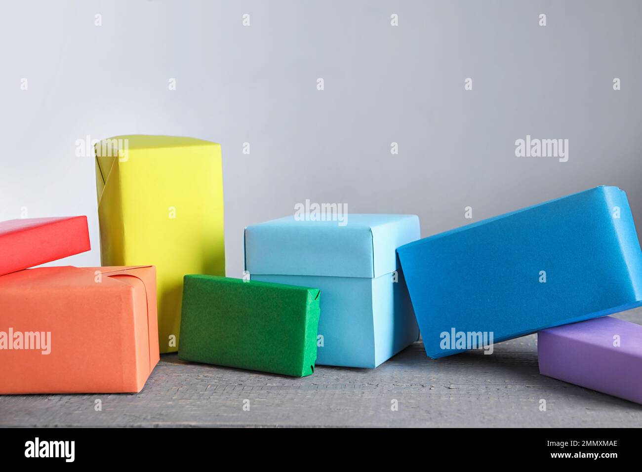 Bright boxes on grey table. Rainbow colors Stock Photo - Alamy