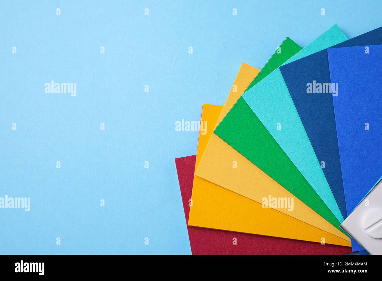 Multicolored paper sheets and space for text on light blue background ...