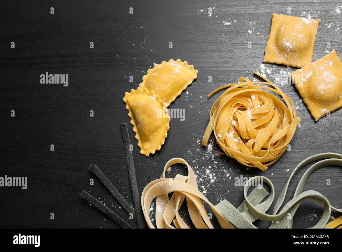 Flat lay composition with different types of pasta on black wooden ...