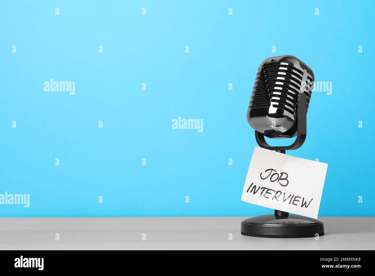 Retro microphone and reminder note with words JOB INTERVIEW on wooden ...