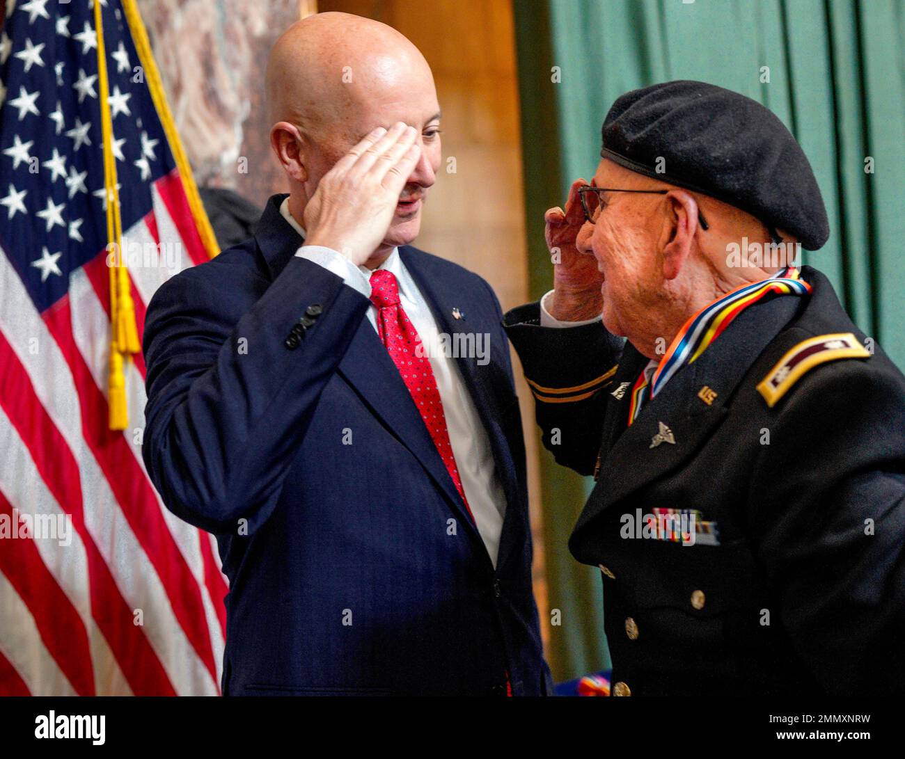 Neb. Gov. Pete Ricketts, left, returns a salute by Korean war veteran ...
