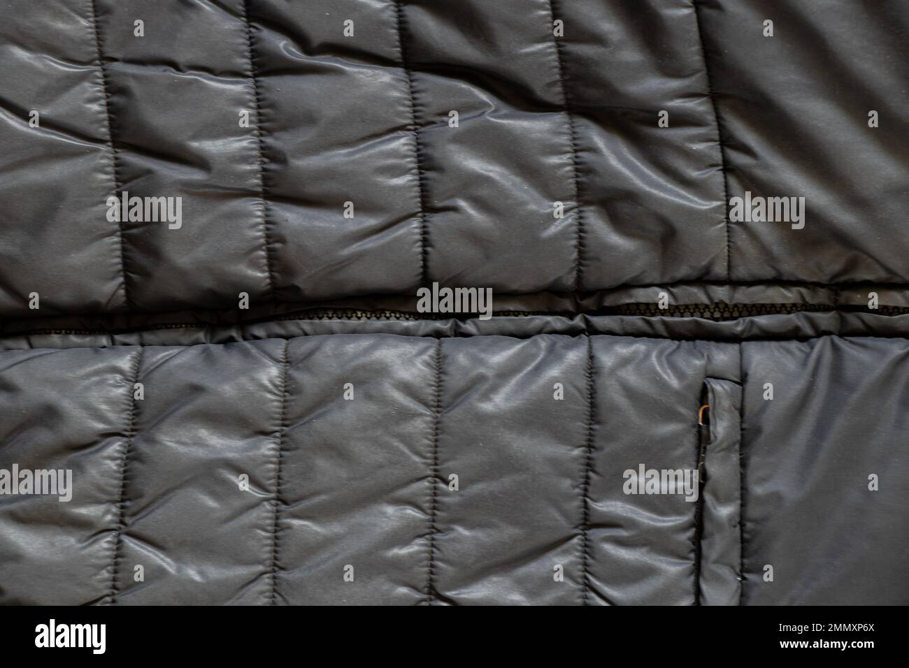 women's insulated black down jacket as a background with an open zipper ...