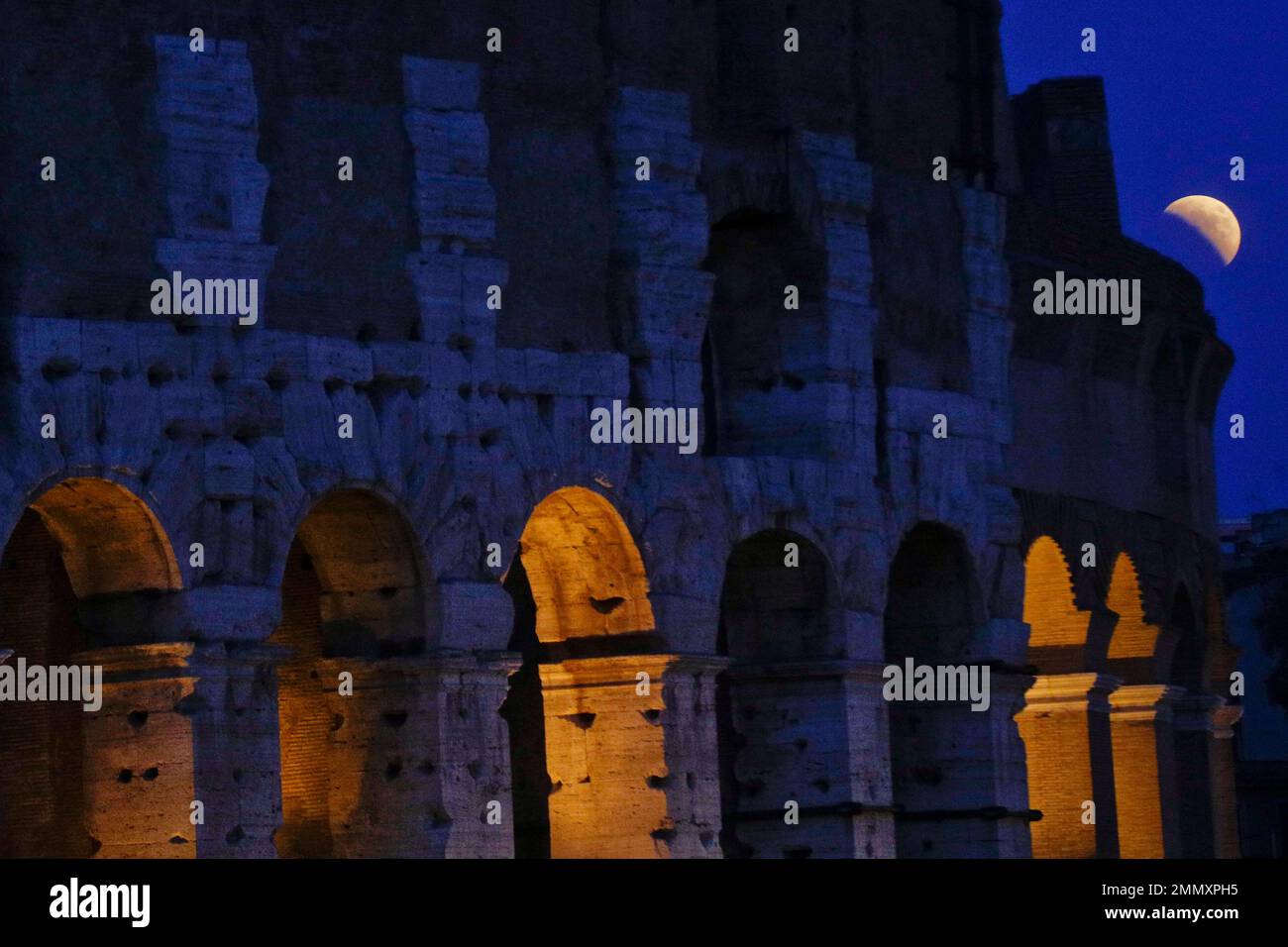 The moon rises past the Colosseum during a complete lunar eclipse, in ...