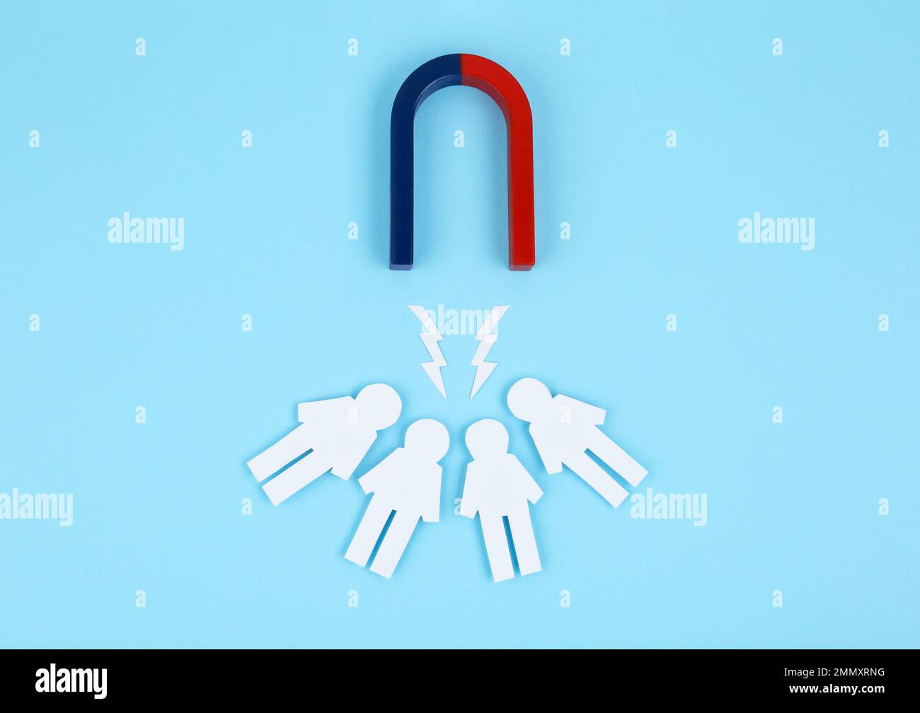 Magnet attracting paper people on light blue background, flat lay Stock ...