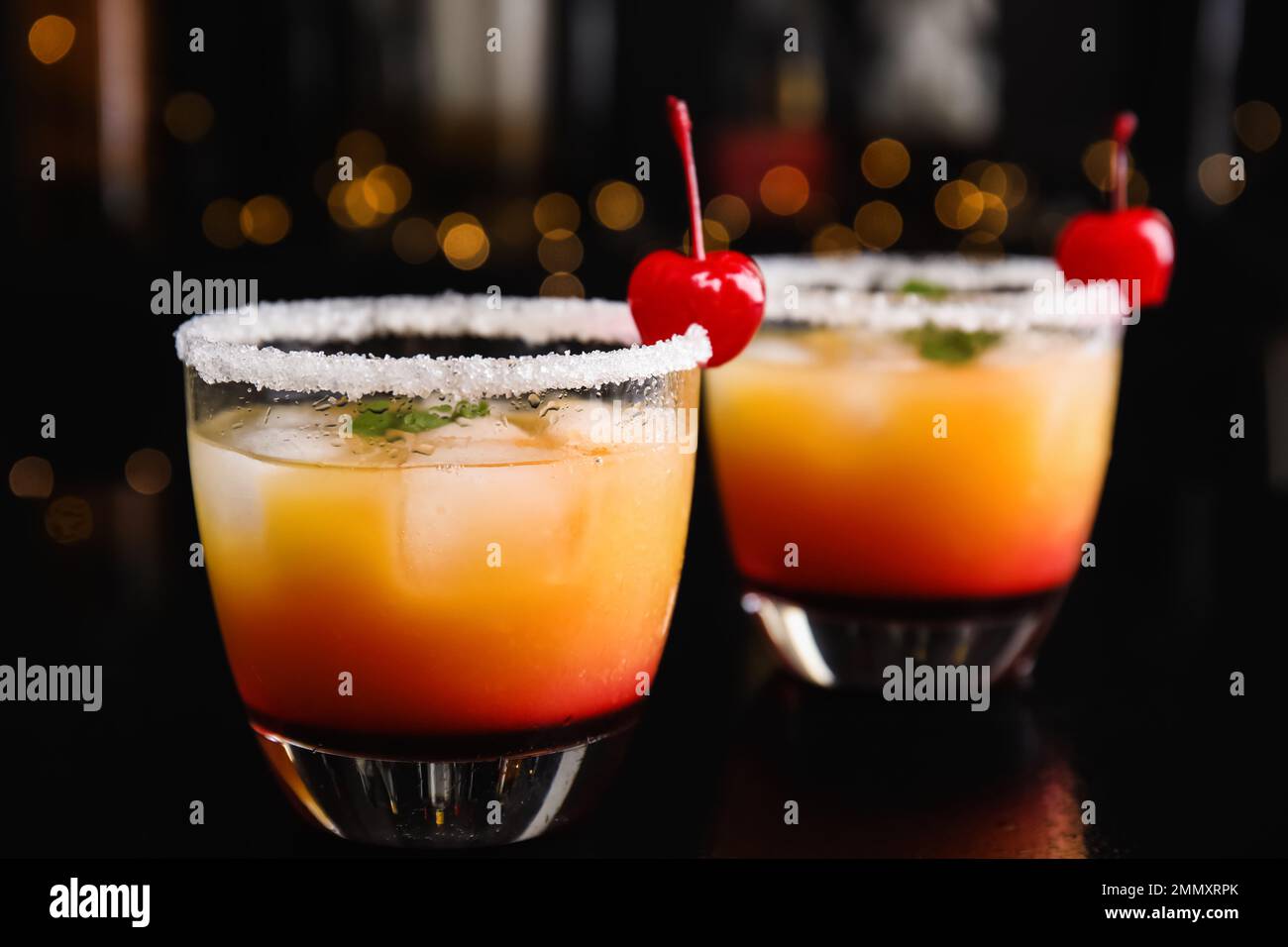 Fresh alcoholic Tequila Sunrise cocktails on black table Stock Photo ...