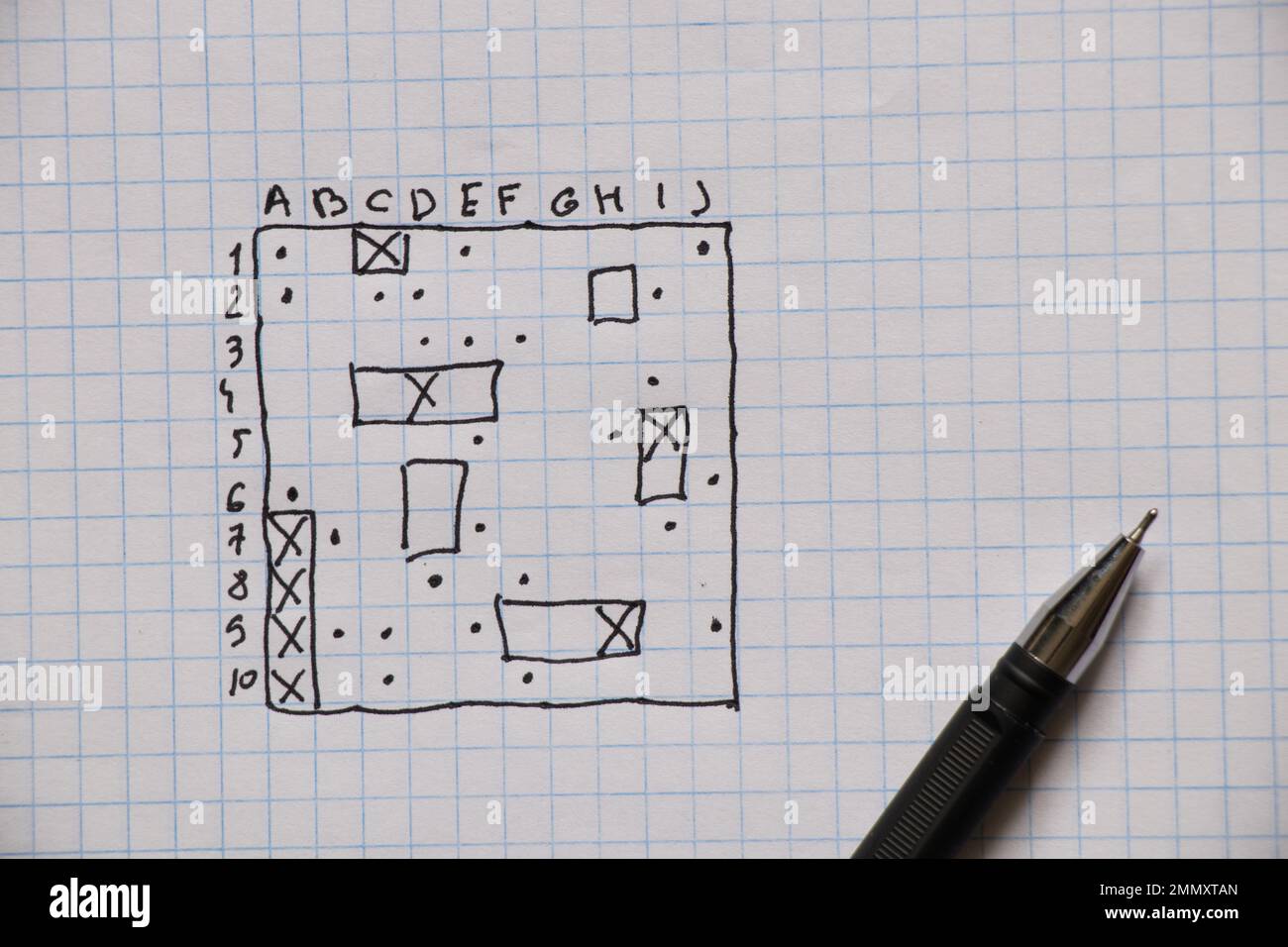 sea battle game, hand-drawn with a pen in a white notebook, rest on a ...